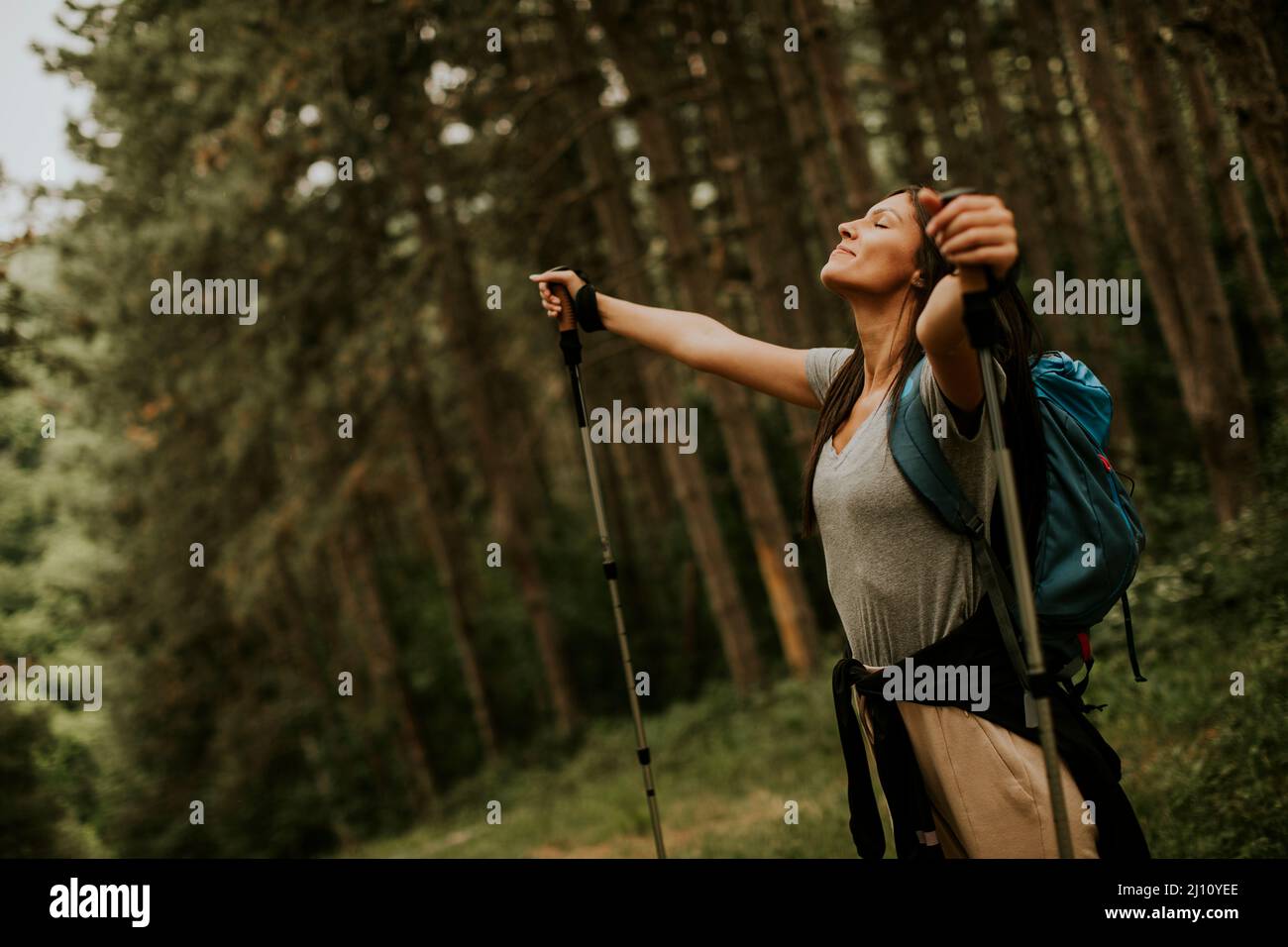 Pretty young female backpacker woman enjoying green beautiful forest ...