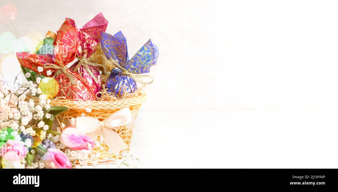 Basket with Easter decorative eggs wrapped in colorful paper with ...