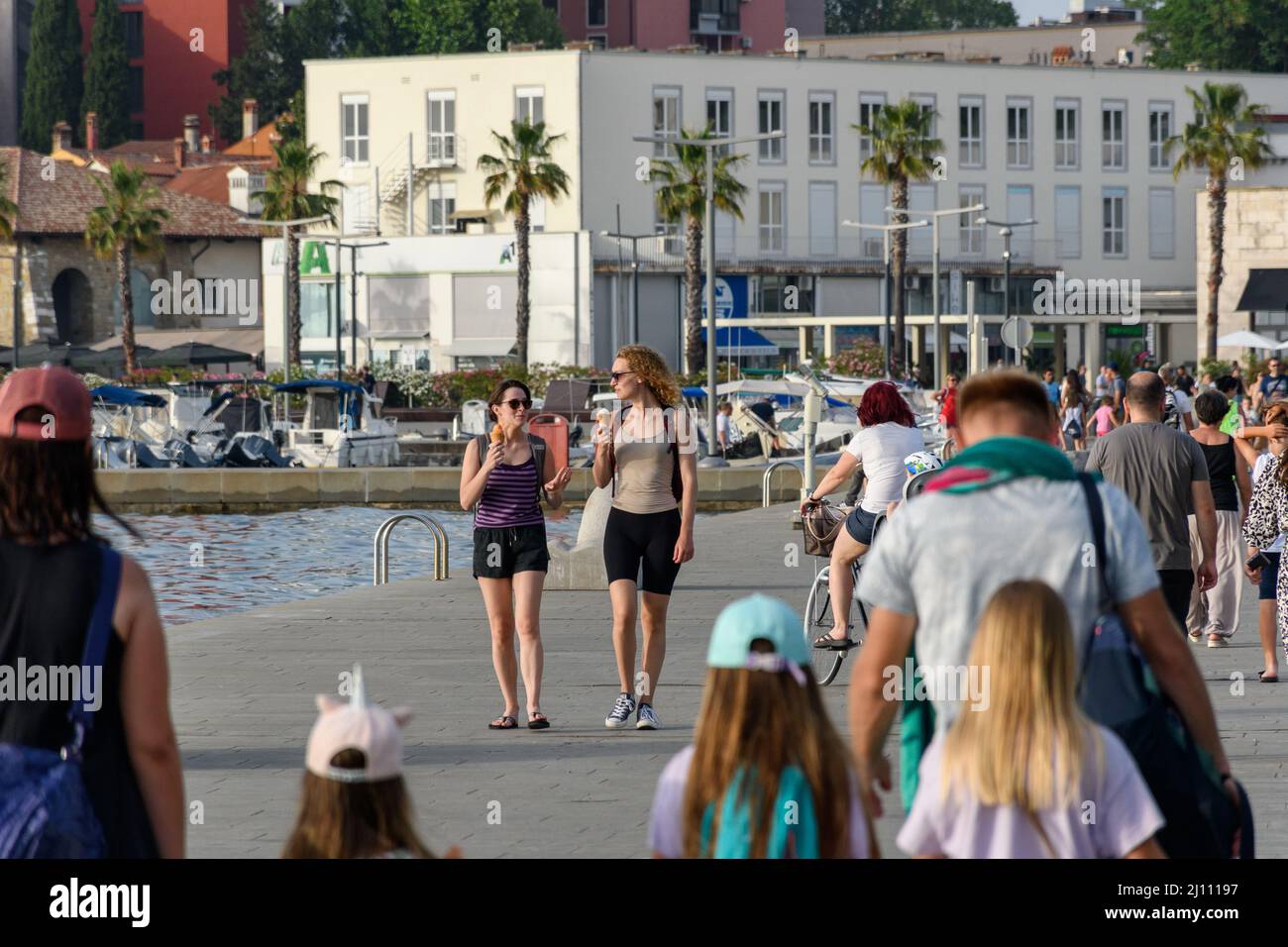 People walking on the waterfront promenade in city of Koper in Slovenia ...