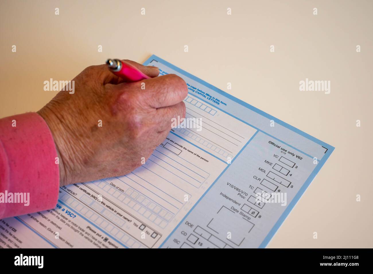 Lady with pen filling in DVLA form on desk in uk Stock Photo - Alamy