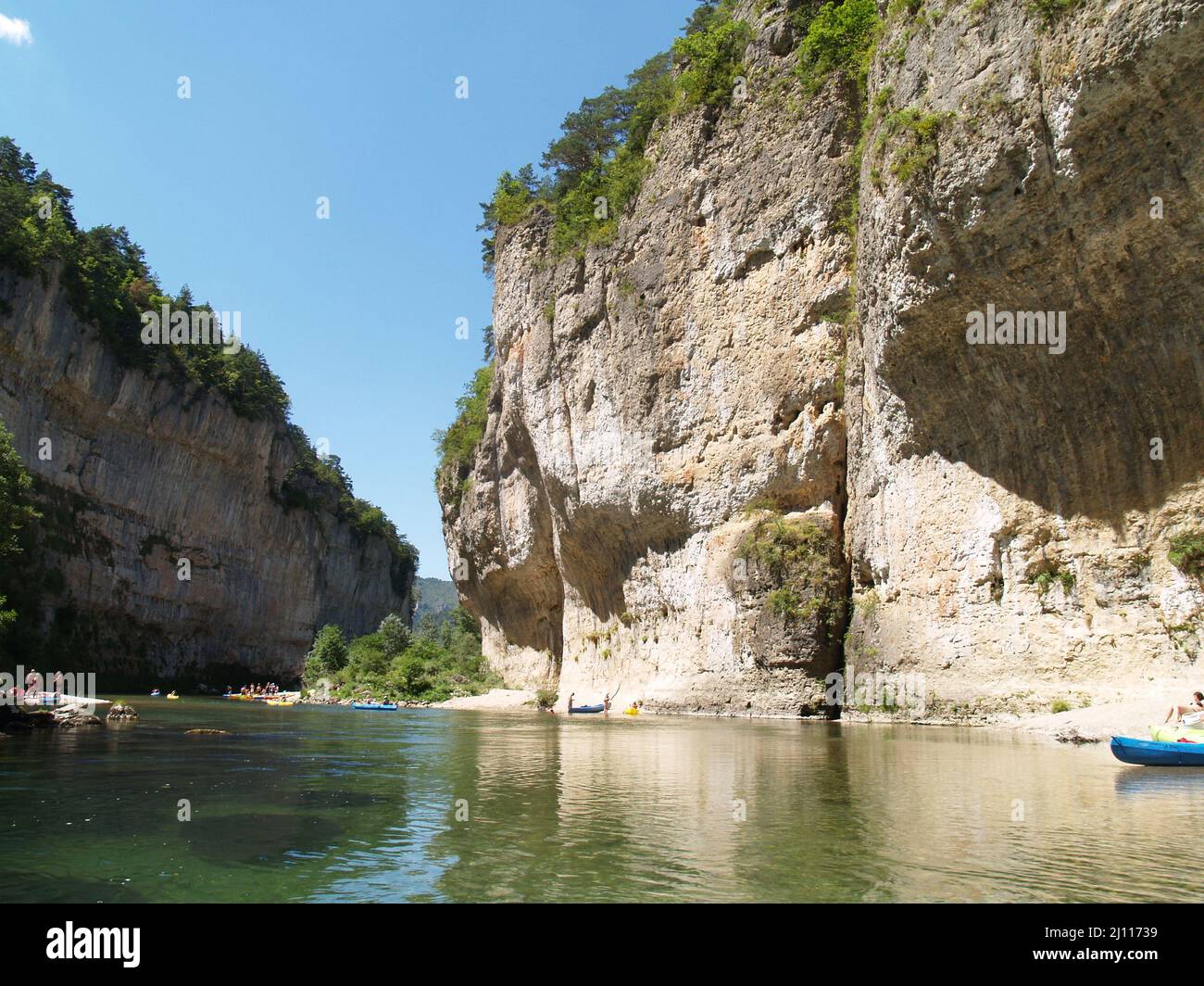 View of a river flowing in a gorge with bushy cliffs from both sides ...