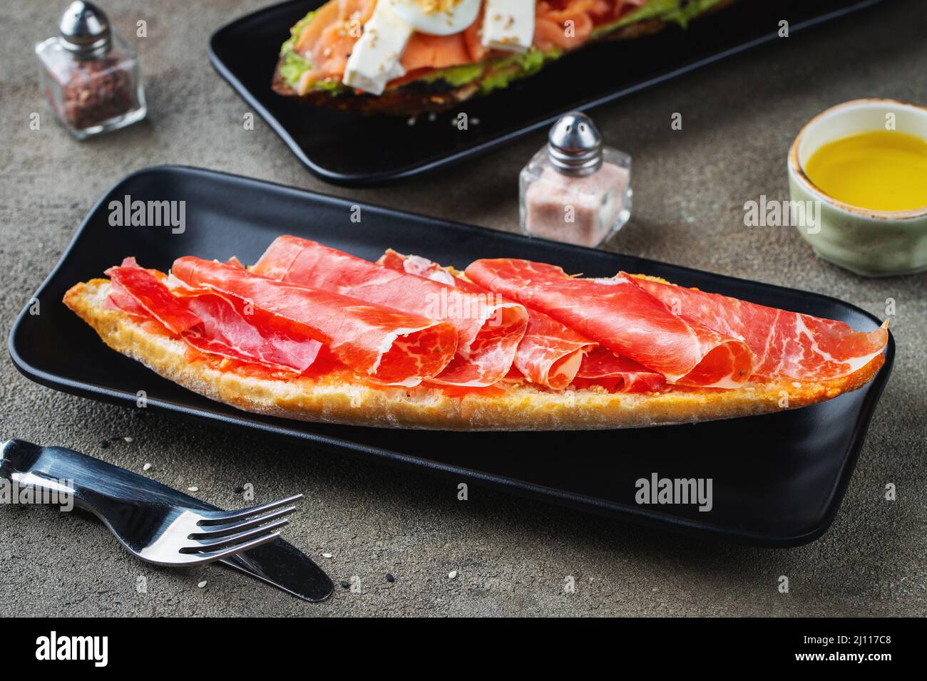 Traditional Spanish breakfast. Tostada with different toppings on a ...