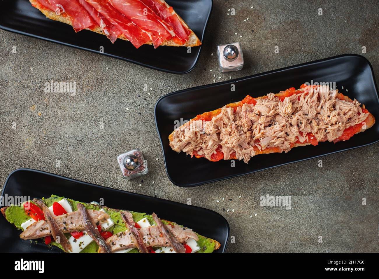 Traditional Spanish breakfast. Tostada with different toppings on a ...