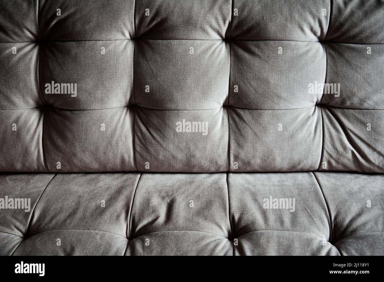 Gray couch surface background with buttons. Sofa pillow detail, close ...