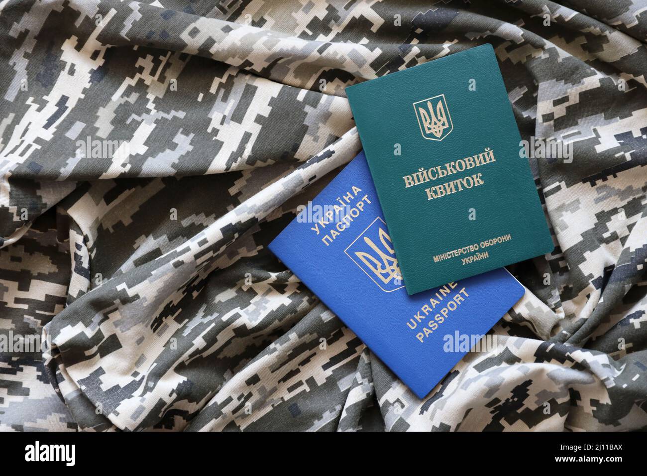 Ukrainian military ID and foreign passport on fabric with texture of ...