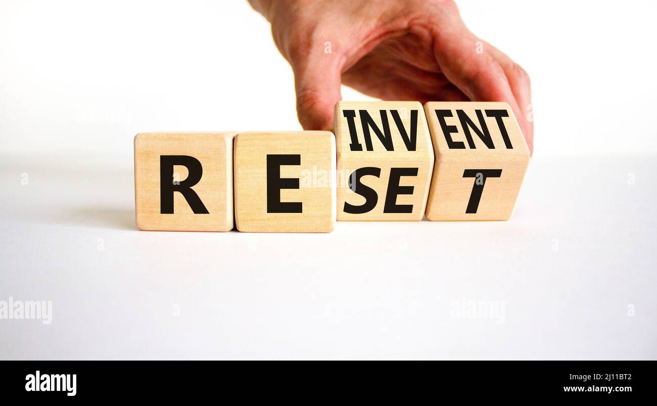 Reinvent and reset symbol. Businessman turns wooden cubes and changes ...