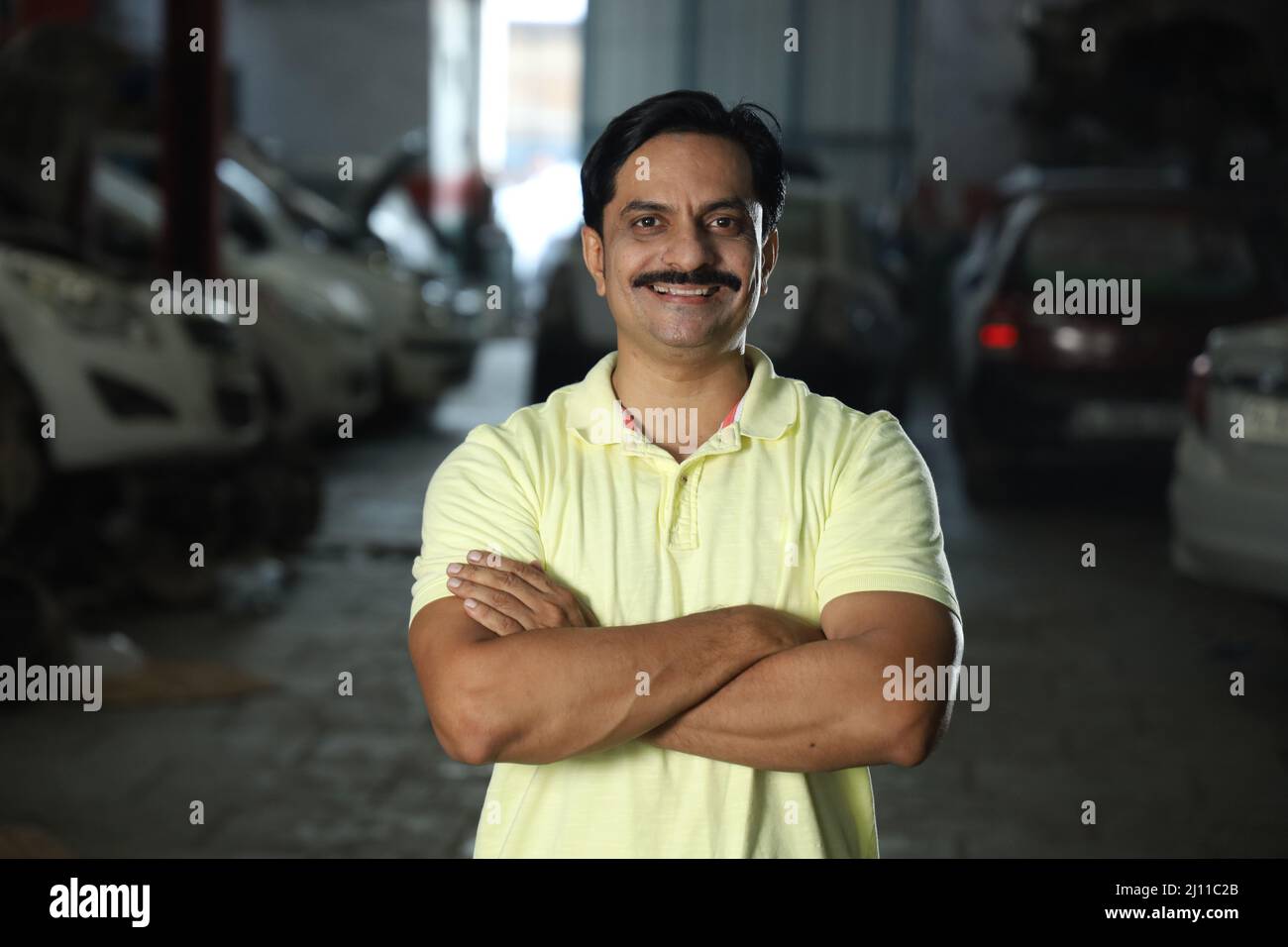 Portrait of a handsome mechanic working on a car in a car service Stock ...