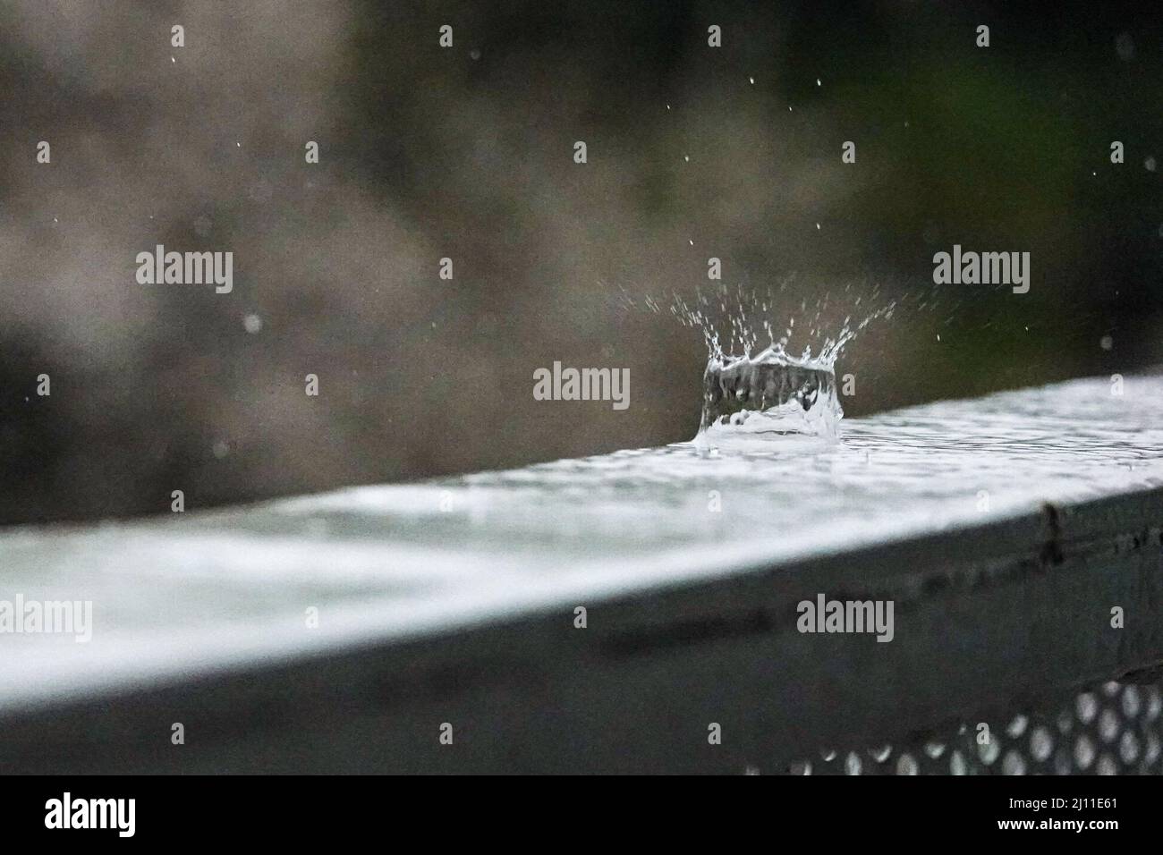 Raindrops fall and make interesting shapes on a cold steel rail Stock ...