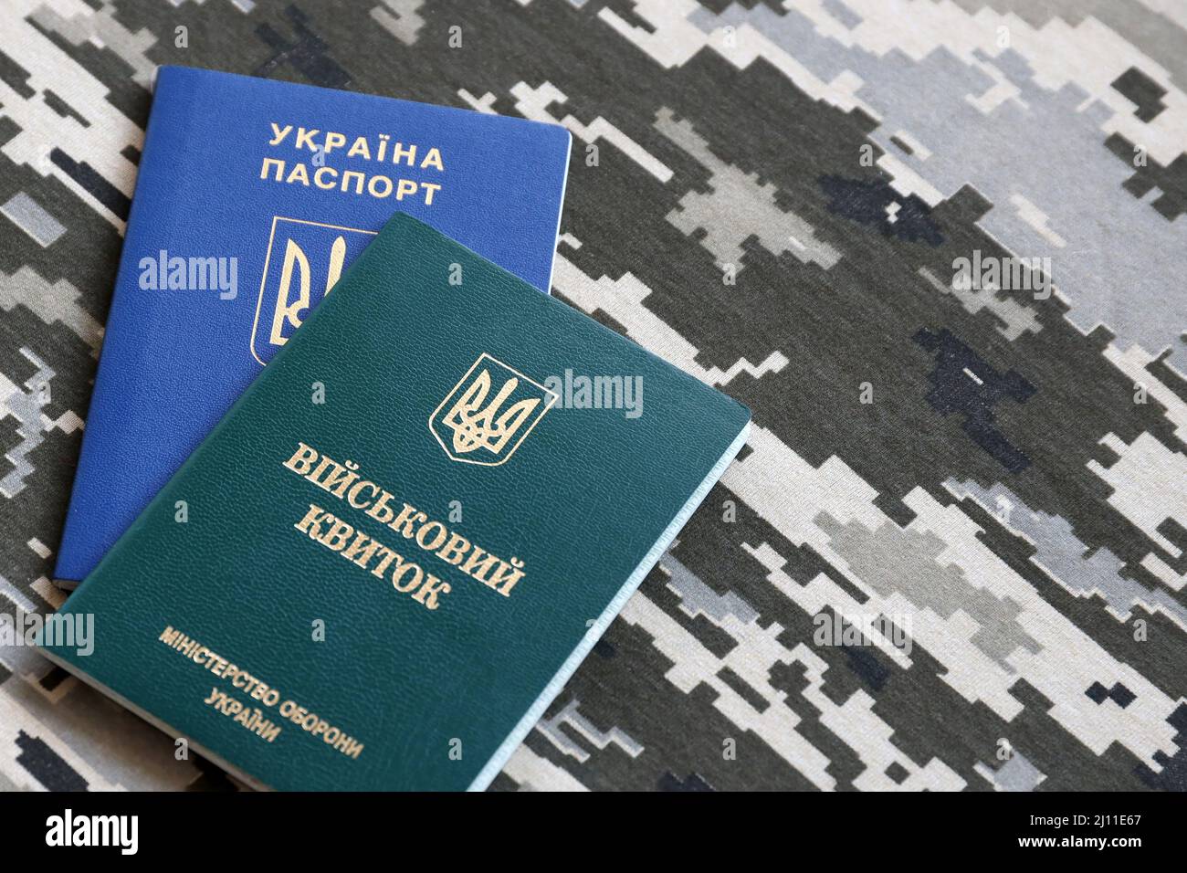 Ukrainian military ID and foreign passport on fabric with texture of ...