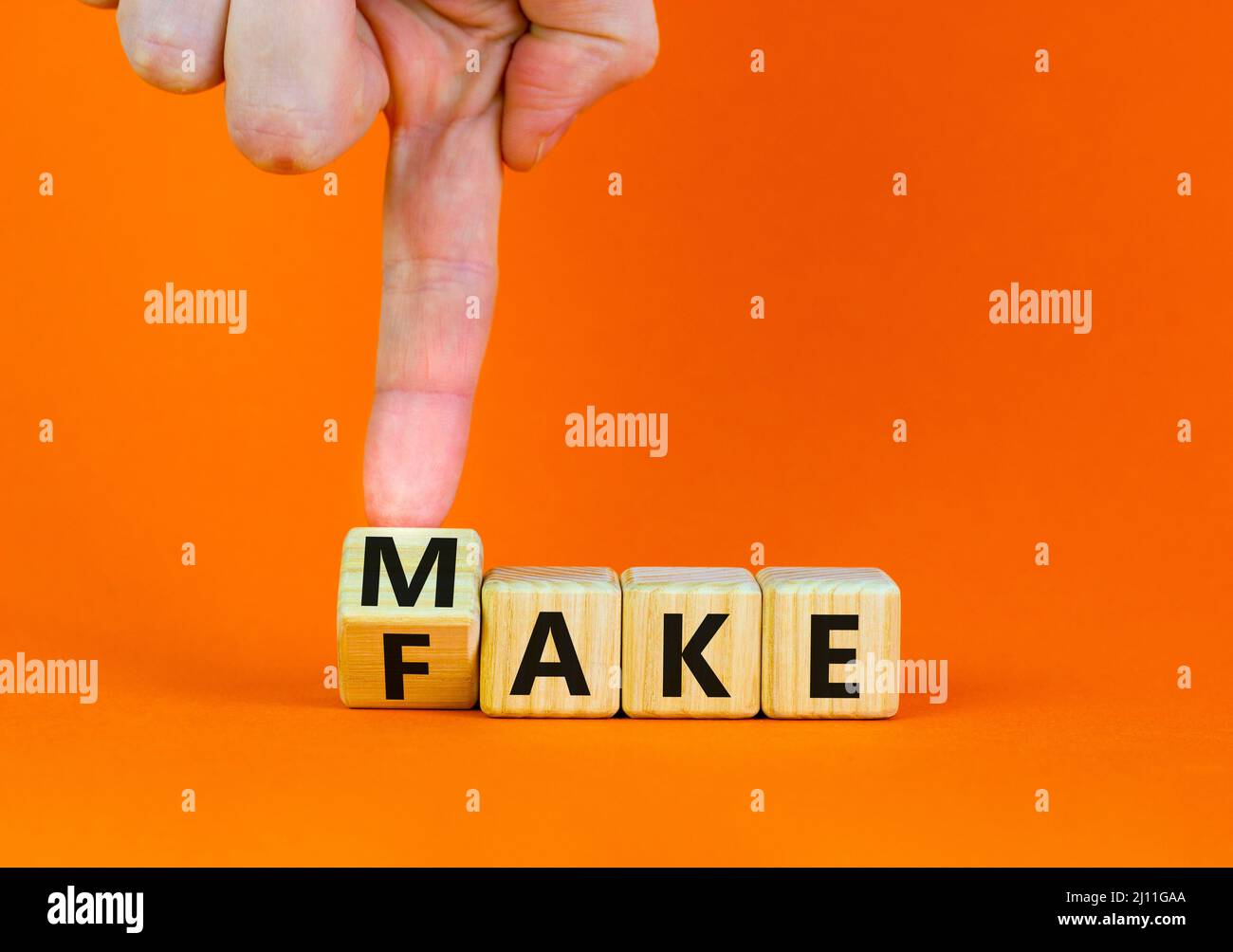 Fake it until you make it symbol. Businessman turns a wooden cube and ...