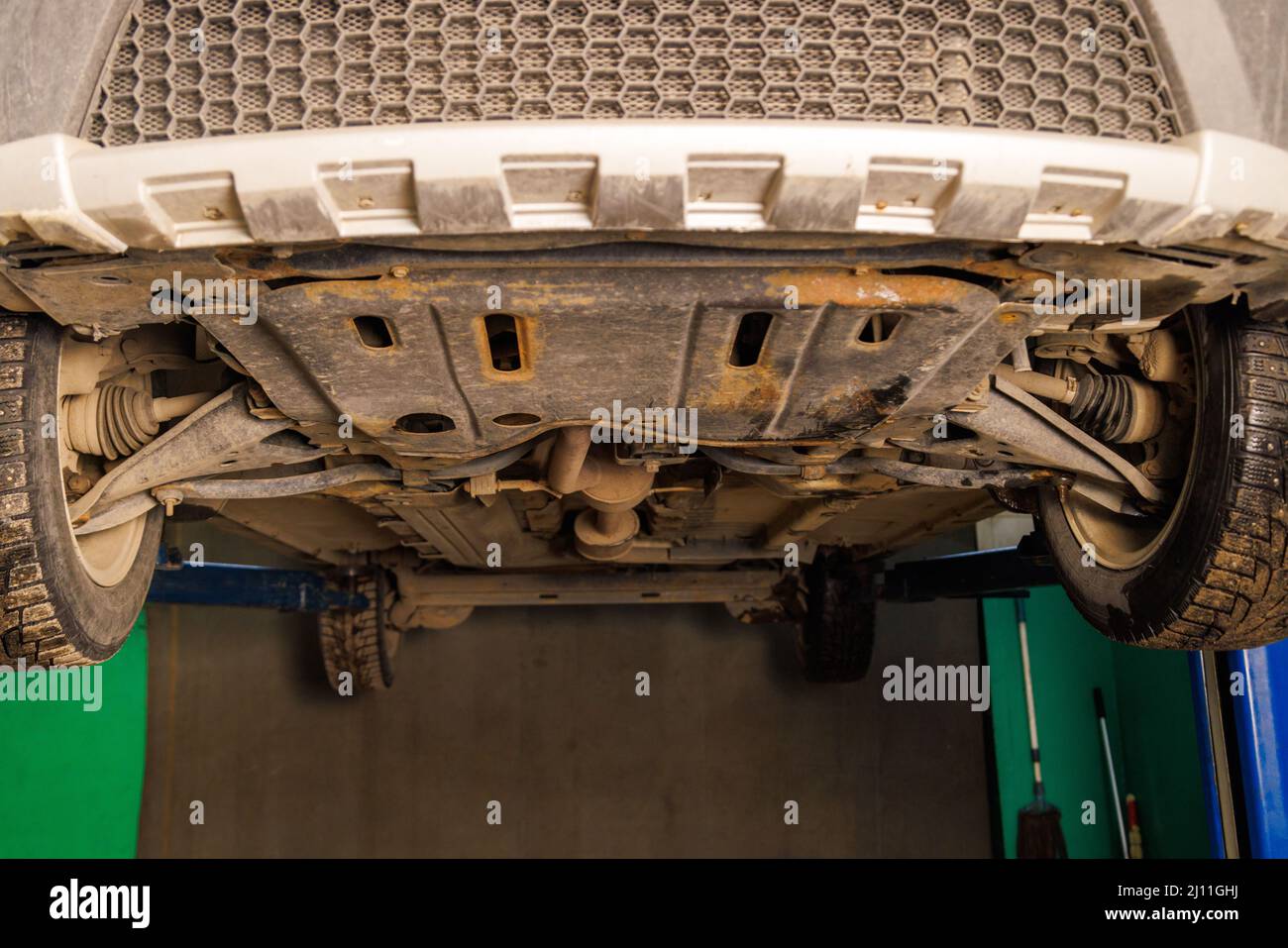 close view of car bottom, lifted in repair and maintenance station ...