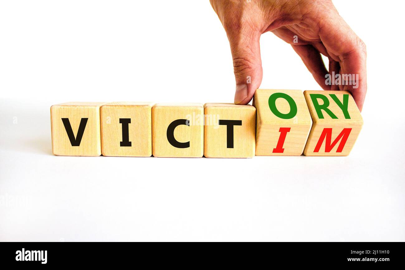 From victim to victory symbol. Businessman turns wooden cubes and ...