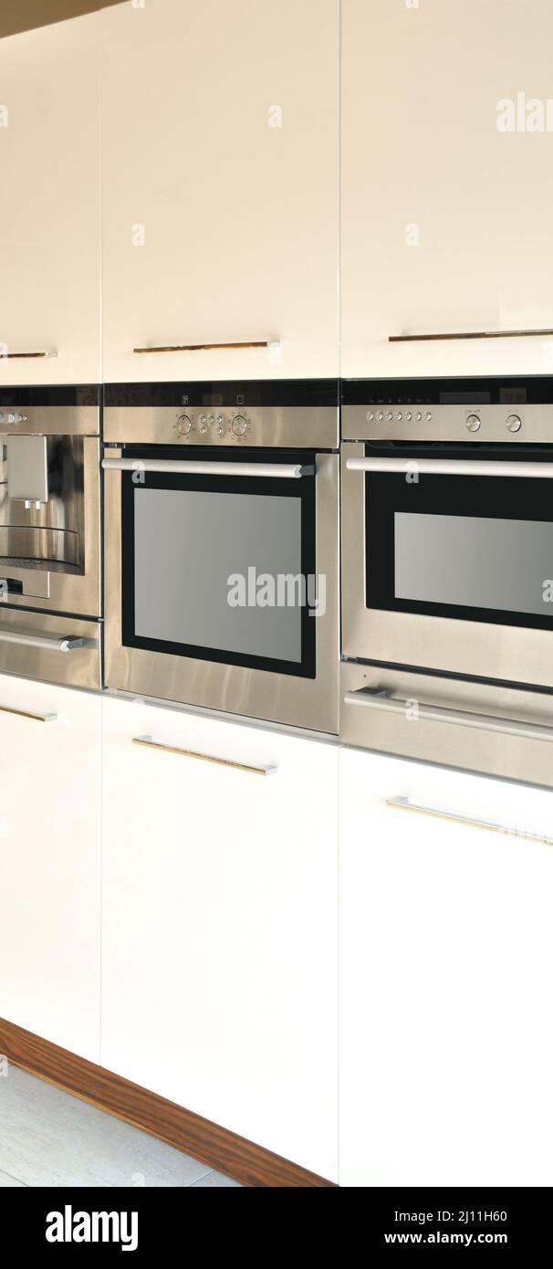 Interior of luxurious modern kitchen equipment, beige lacquer cabinets ...