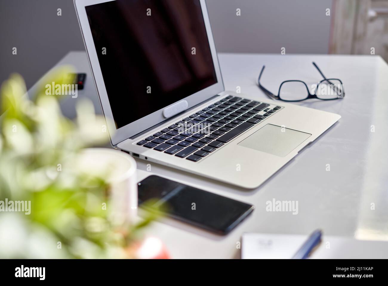 Cosy home office desk with laptop computer and phone. Still life, no ...