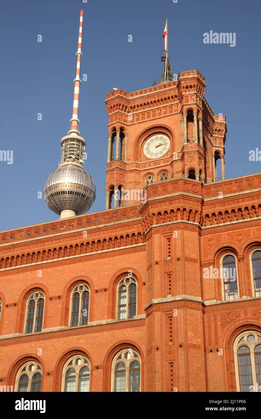 Vertical, low angle shot of an orange building with a TV tower on the ...