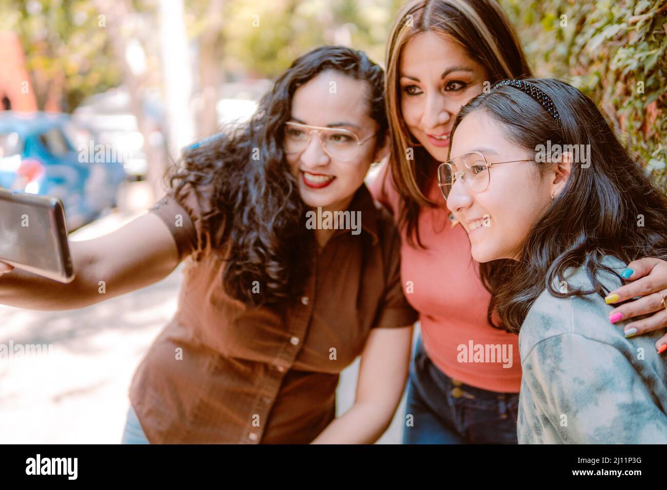 Three Girls Taking Selfie In The Street Looking Happy Because They