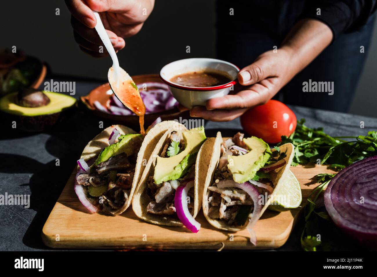 Mexican woman hands preparing tacos with sauce traditional food in ...