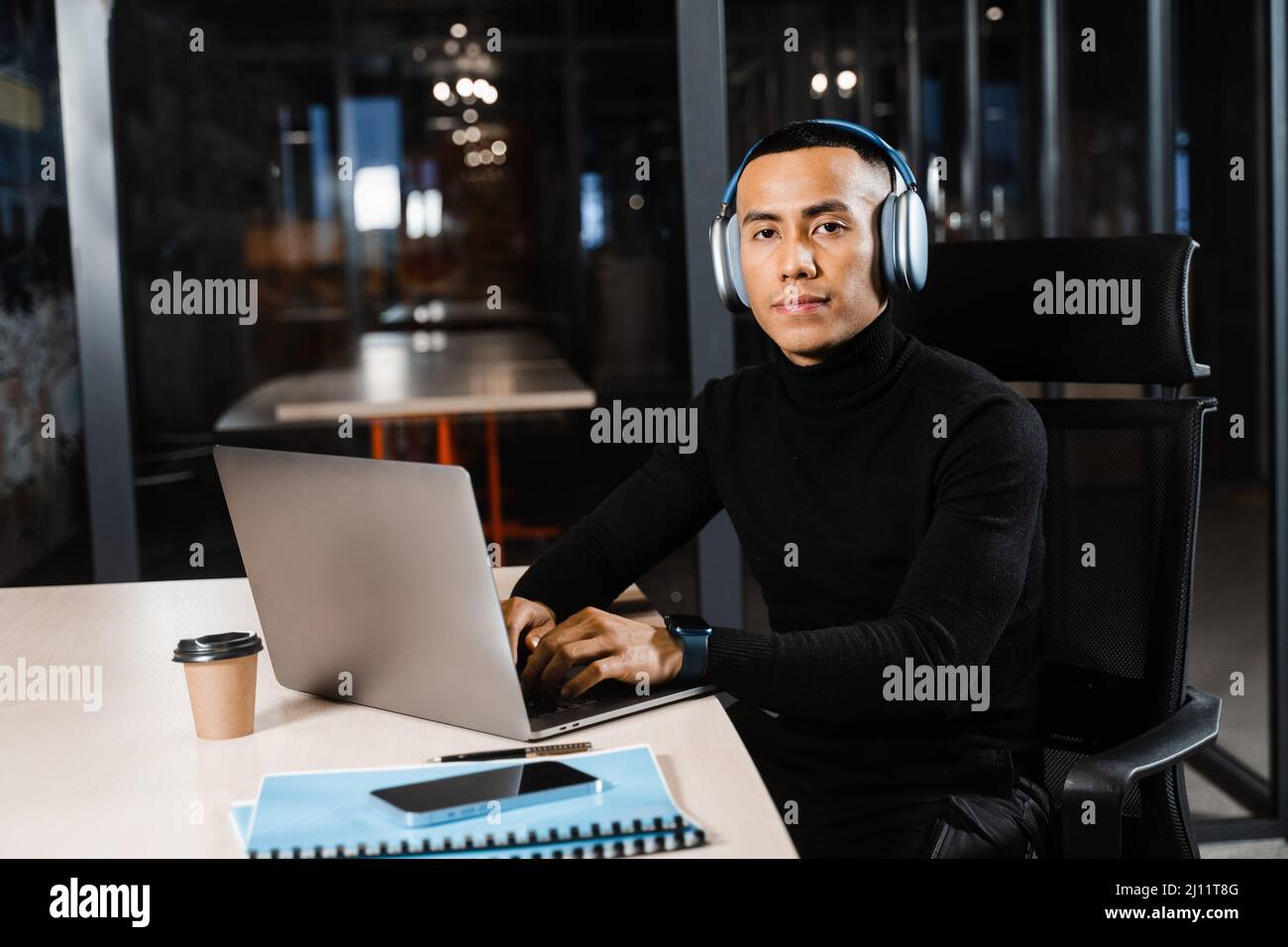Handsome asian student with laptop and headphones is doing distance ... Handsome asian student with laptop and headphones is doing distance ...