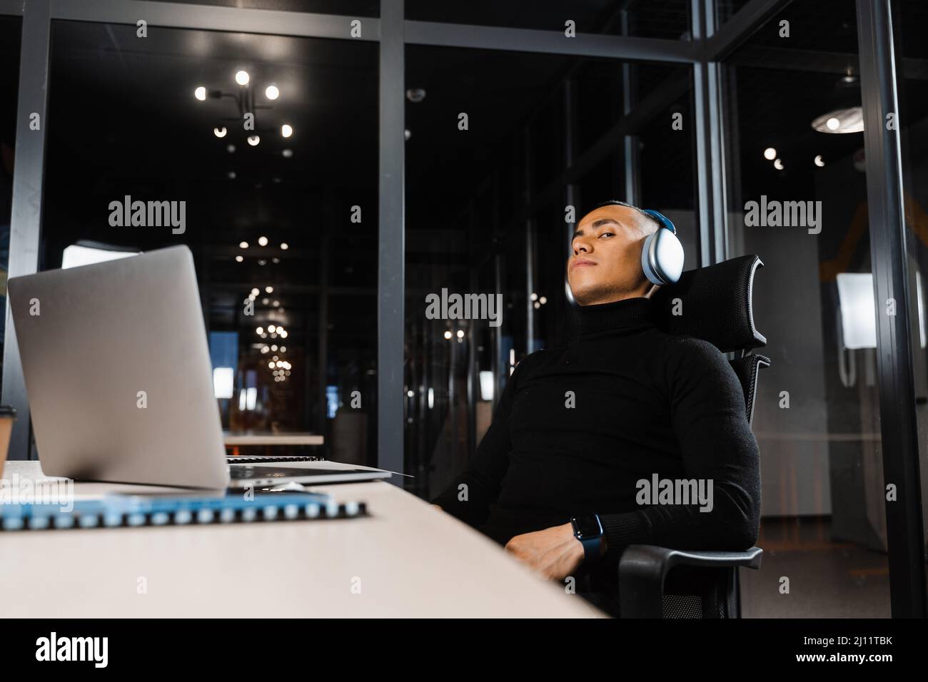 Overtime working. Asian man with closed eyes is resting at work at ...