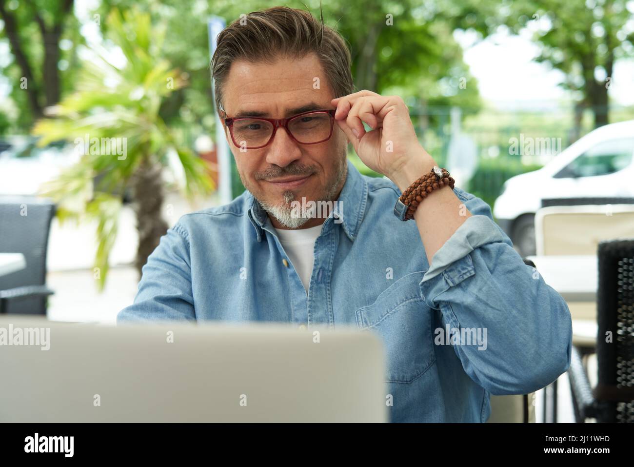 Outdoor portrait of mid adult man in 50s, happy confident smile ...