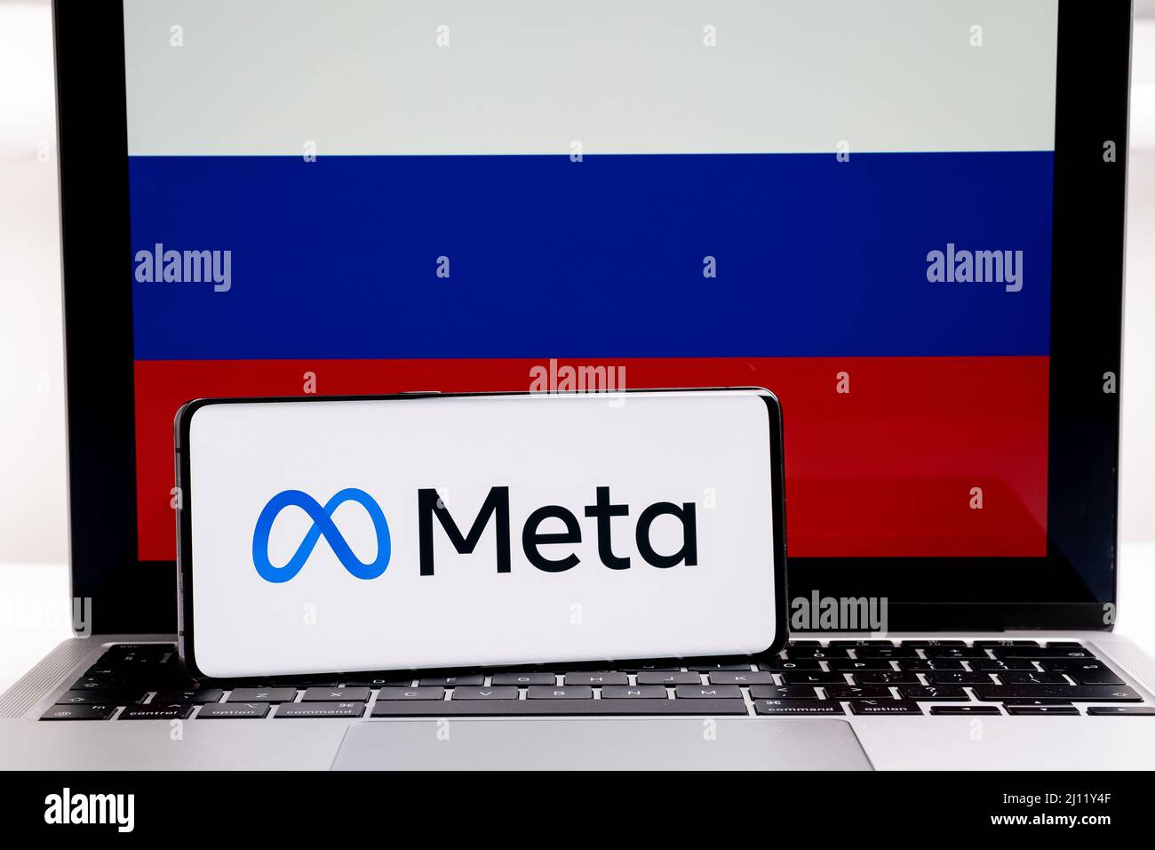Facebook Meta company logo seen on smartphone which is place on laptop ...