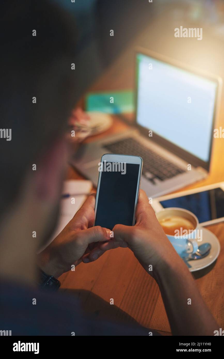 Sending out a project update. Rearview shot of a young man using his ...