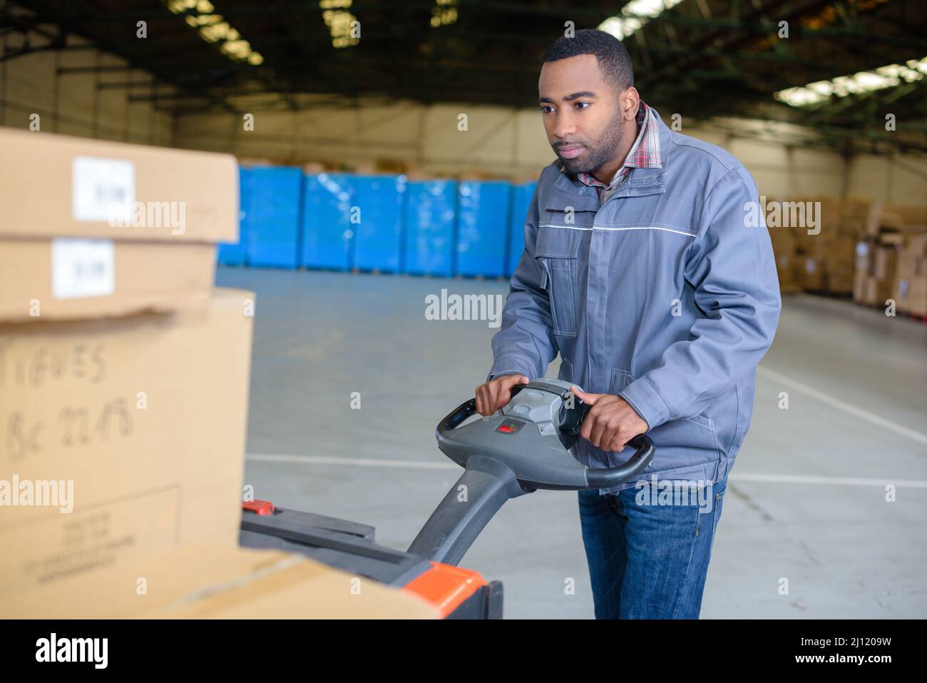 warehouse worker using electric pallet truck Stock Photo - Alamy