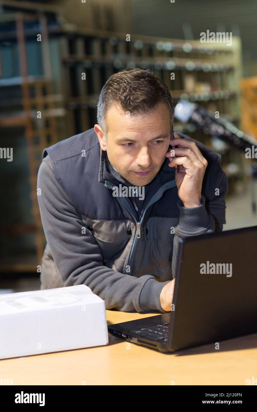 portrait of a man with laptop phoning Stock Photo - Alamy