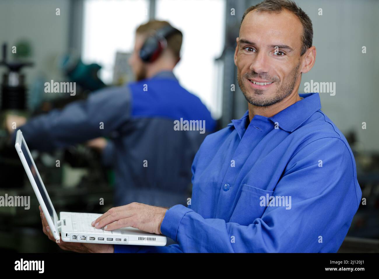 happy mechanic diagnosing car problem with computer Stock Photo - Alamy
