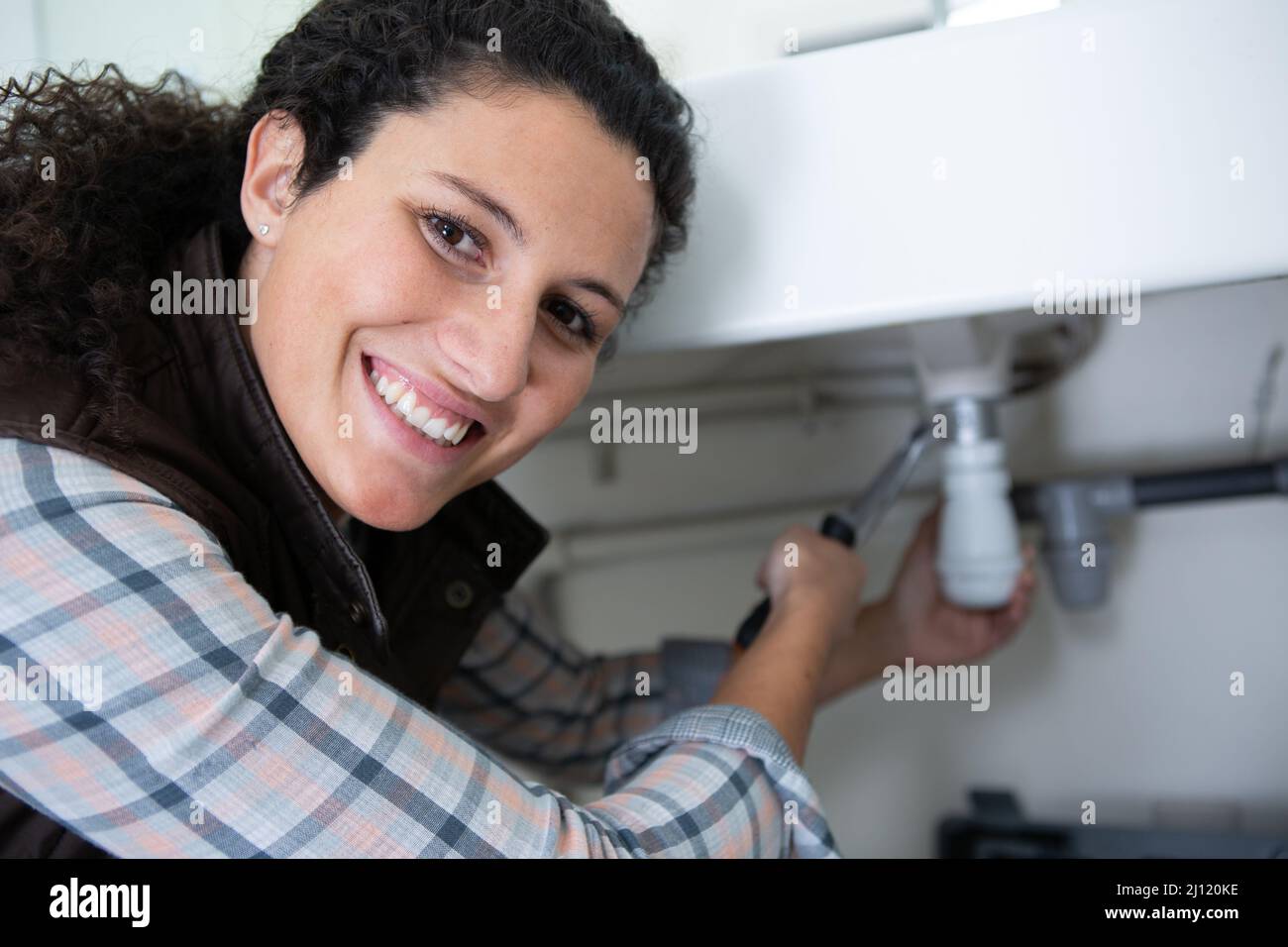 young woman plumber fitting the waste on a kitchen sink Stock Photo - Alamy