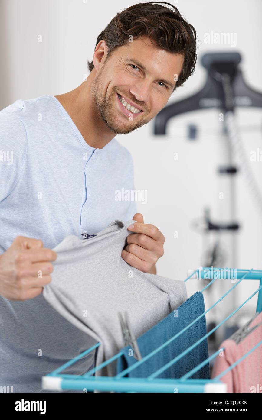 man hanging clothes on the indoor laundry line Stock Photo - Alamy
