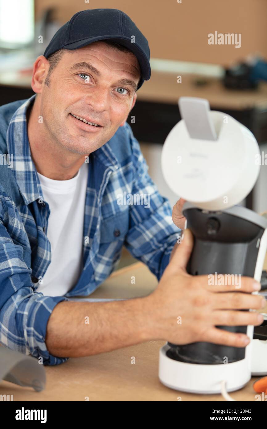 happy man repairing broken coffee machine Stock Photo - Alamy