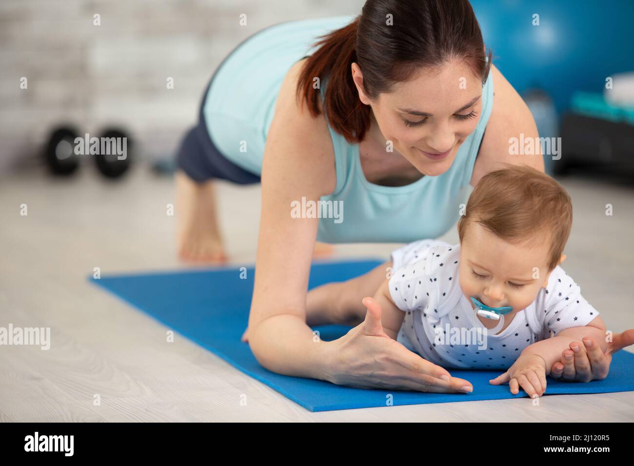 athletic mother exercising in plank position with baby Stock Photo - Alamy