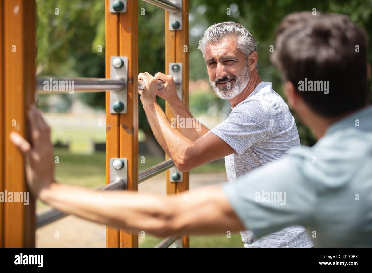 strong young men doing extreme pull-ups Stock Photo - Alamy