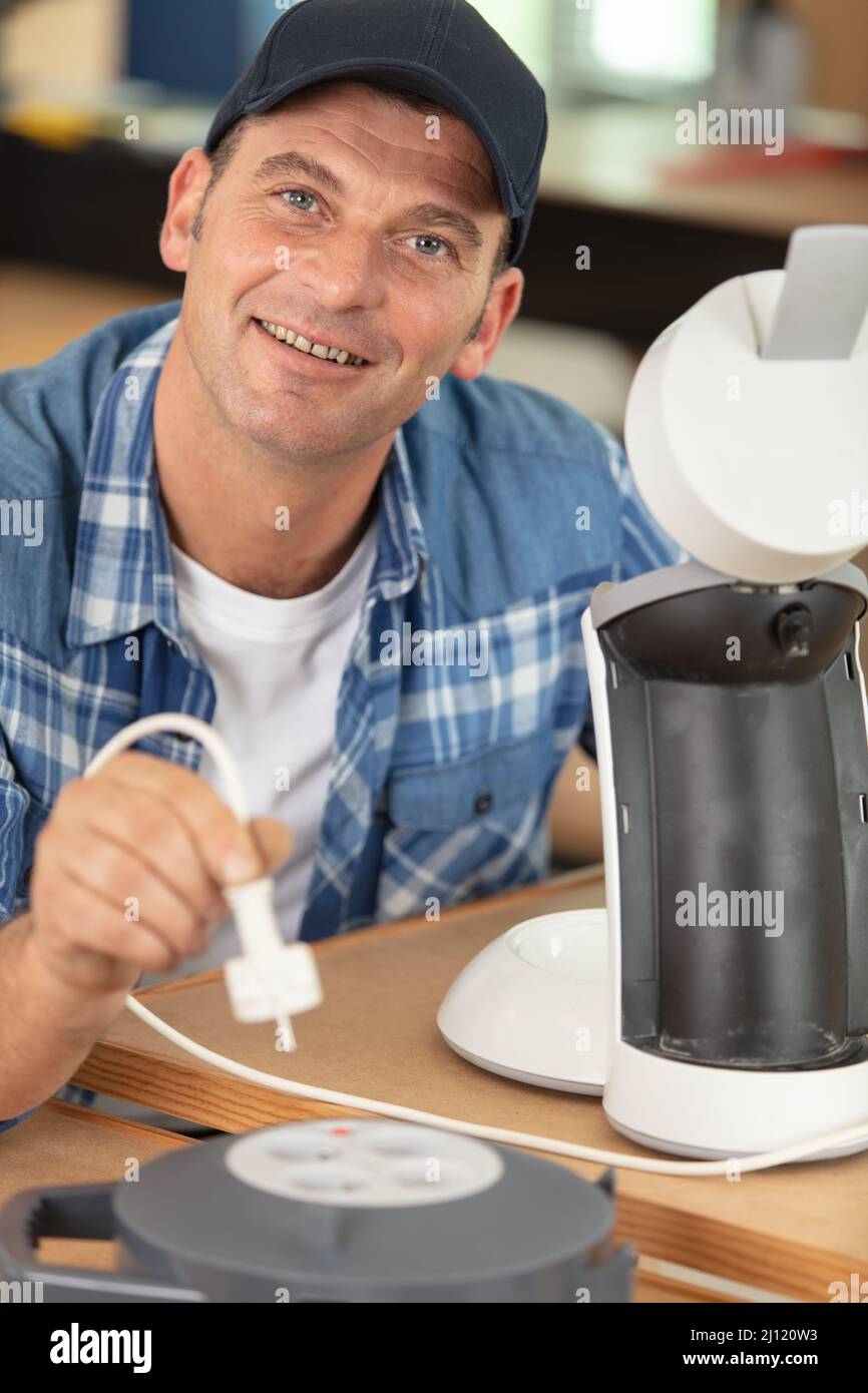 man in workshop plugs in a coffee machine Stock Photo - Alamy