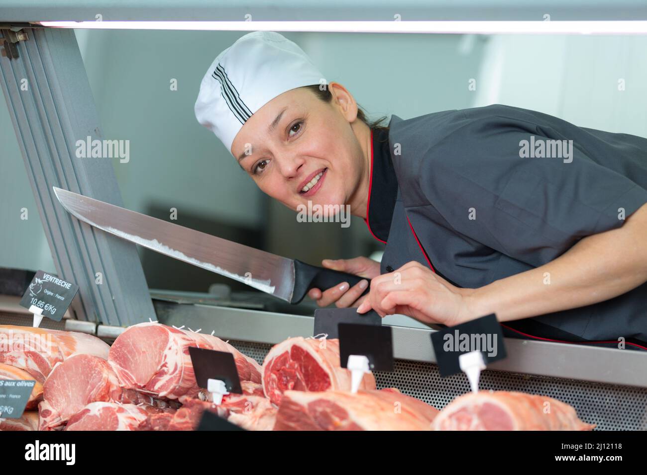 portrait of woman butcher cutting meat Stock Photo - Alamy