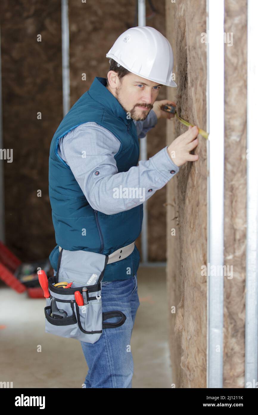 a man builder is measuring a wall Stock Photo - Alamy