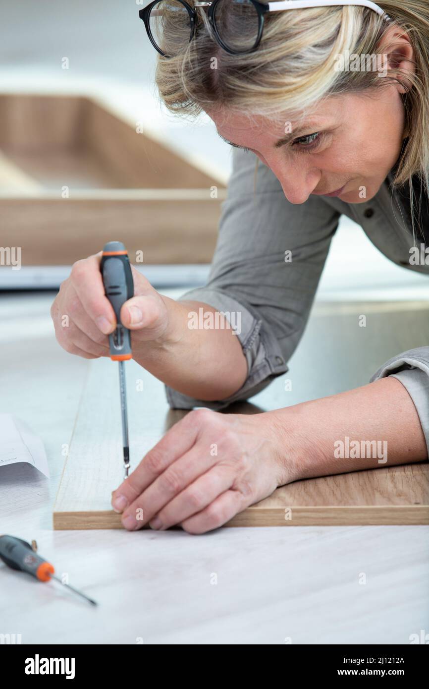 woman assembling wooden furniture using screwdriver Stock Photo - Alamy