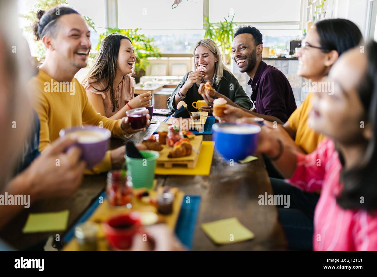 Multiracial people gathering together while having breakfast on rooftop ...