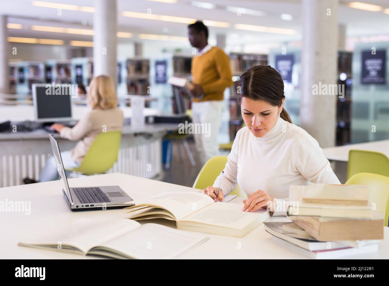 Successful woman studying in the library Stock Photo - Alamy