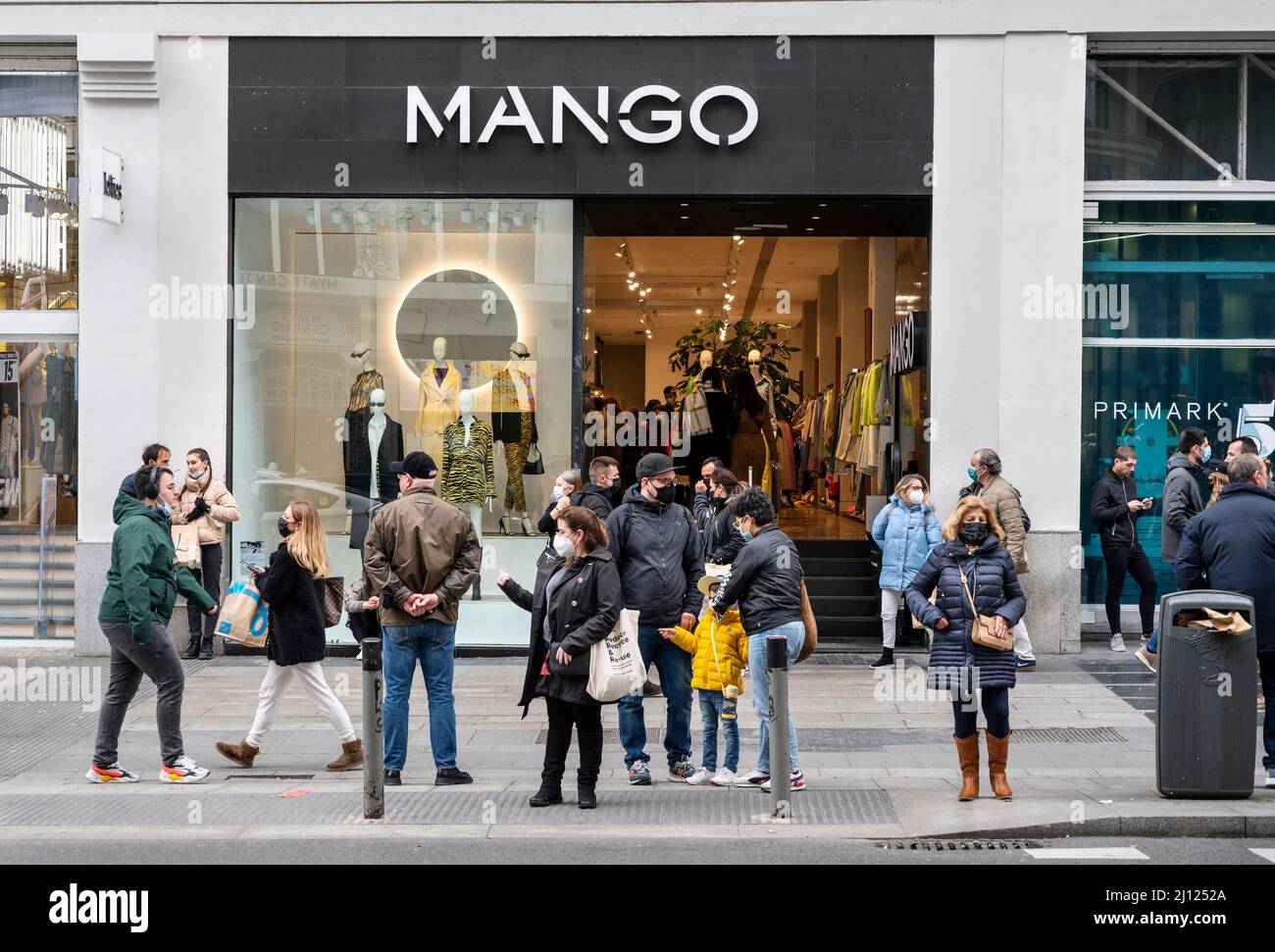 Pedestrians wait at a traffic light in front of the Spanish ...
