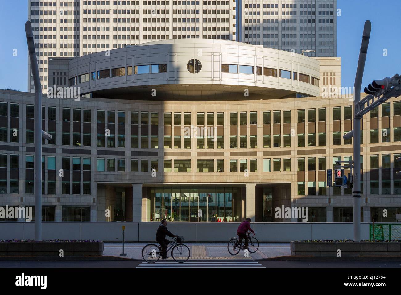 Bicycles being ridden in front of building in the Tokyo Metropolitan ...