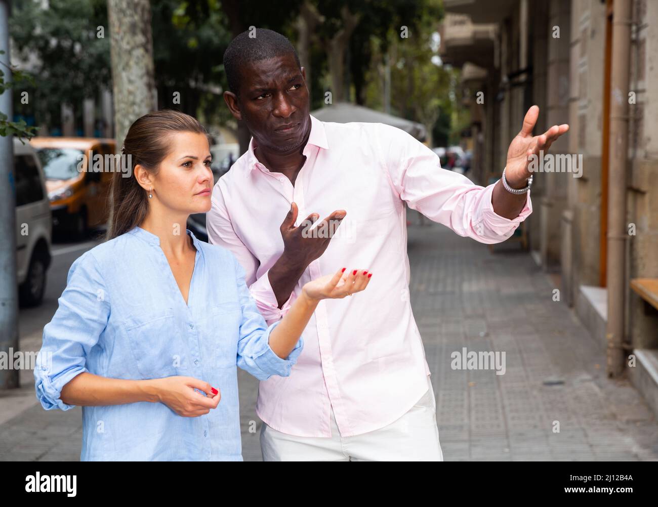 Woman asking man to show way Stock Photo - Alamy
