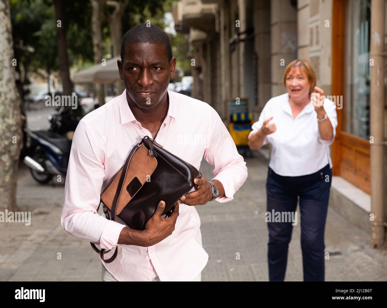 Man running away with handbag stolen from aged woman Stock Photo - Alamy