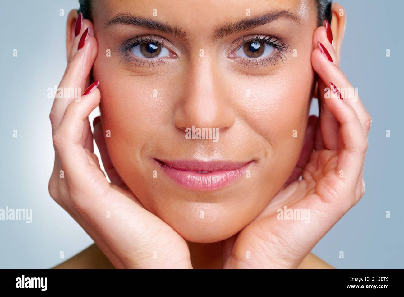 Macro view of a beautiful young woman with hands on chin. Detail shot ...
