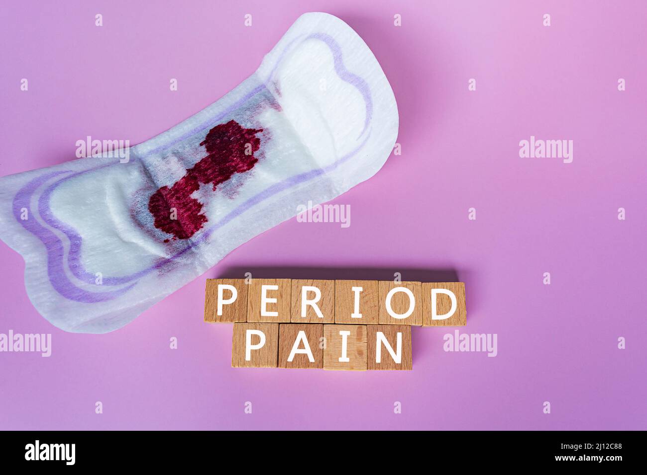 Period pain text on wooden block. Woman hygiene protection. Sanitary ...