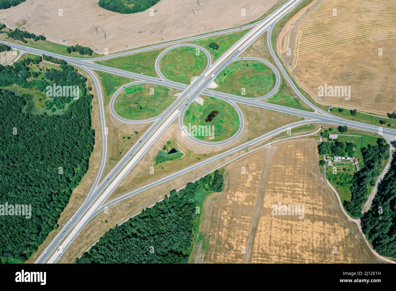 aerial view of a highway intersection with a clover-leaf interchange ...