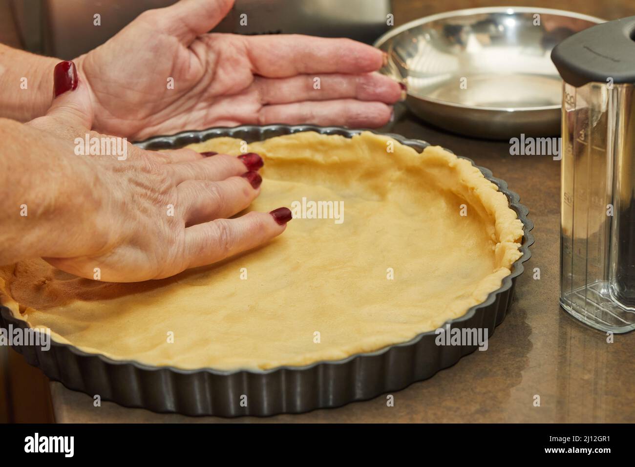 Chef prepares pie and puts the dough into mold Stock Photo - Alamy