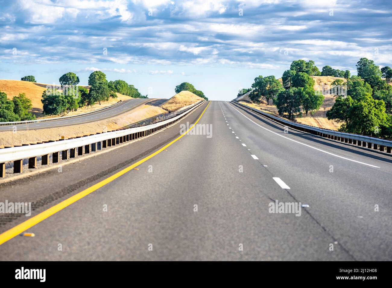 Scenic summer landscape with a disappearing at horizon straight highway ...