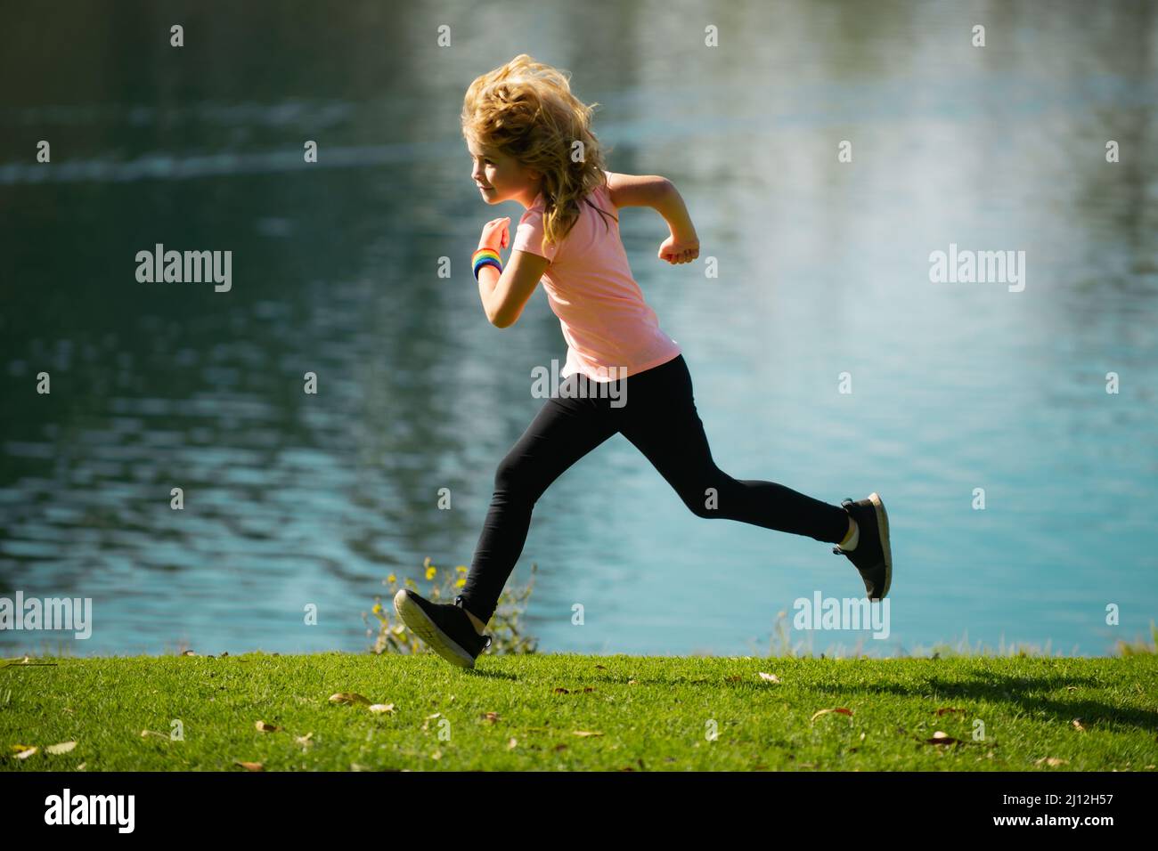 Child boy running outdoors. Kid running in a summer park. Morning ...